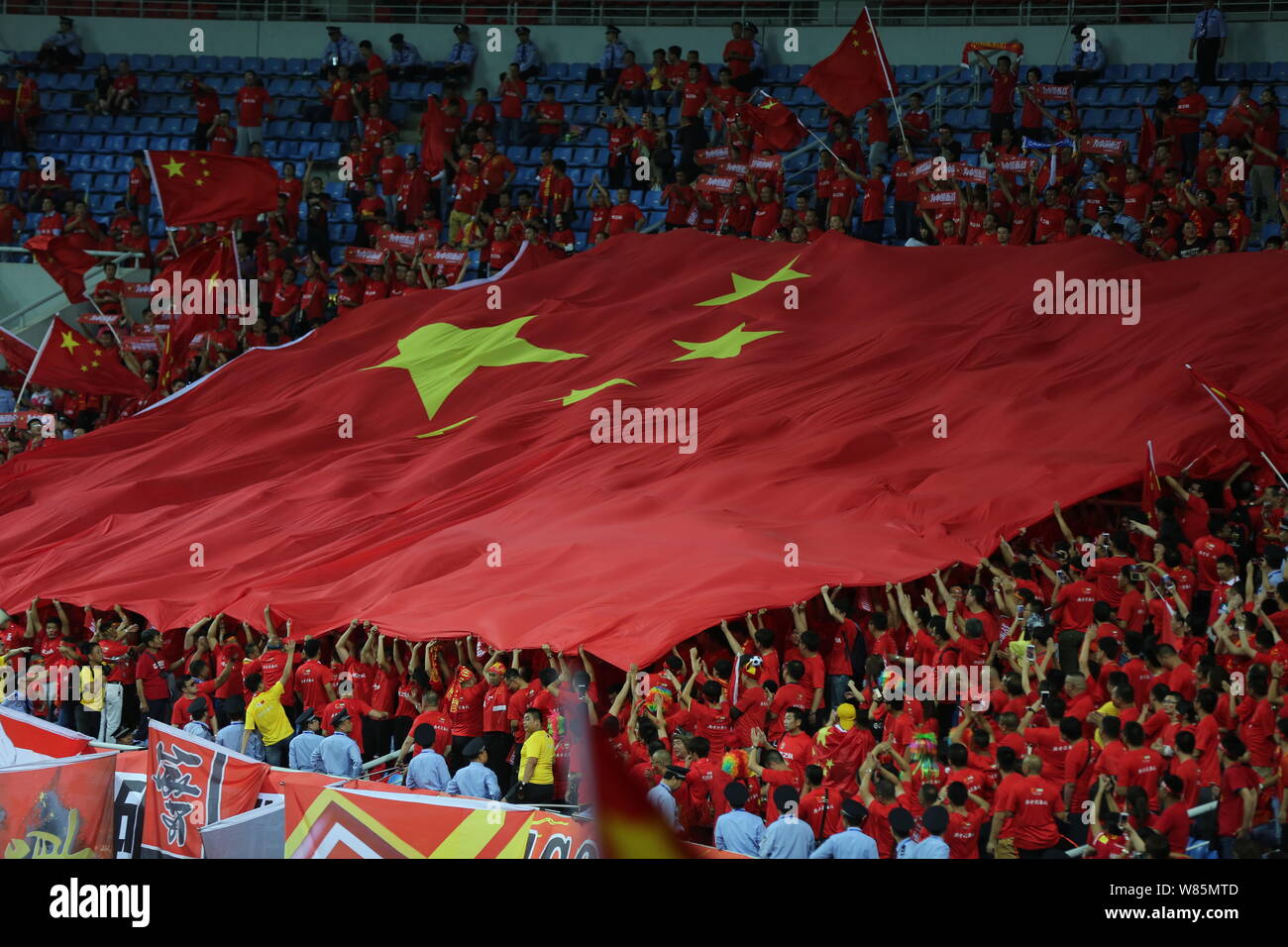 Chinese football fans pass on a giant national flag to show support for ...