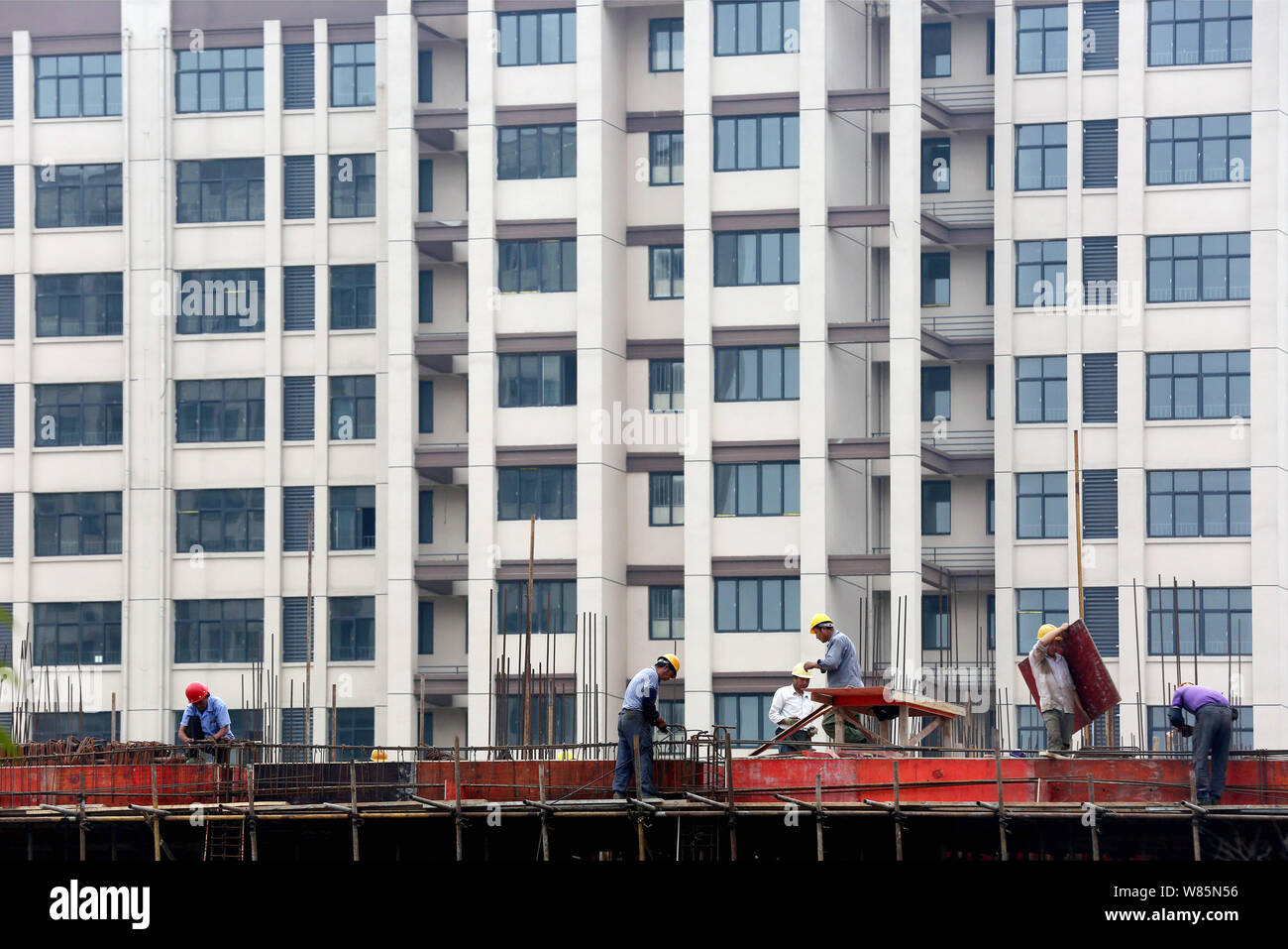Chinese migrant workers construct a residential apartment building in ...