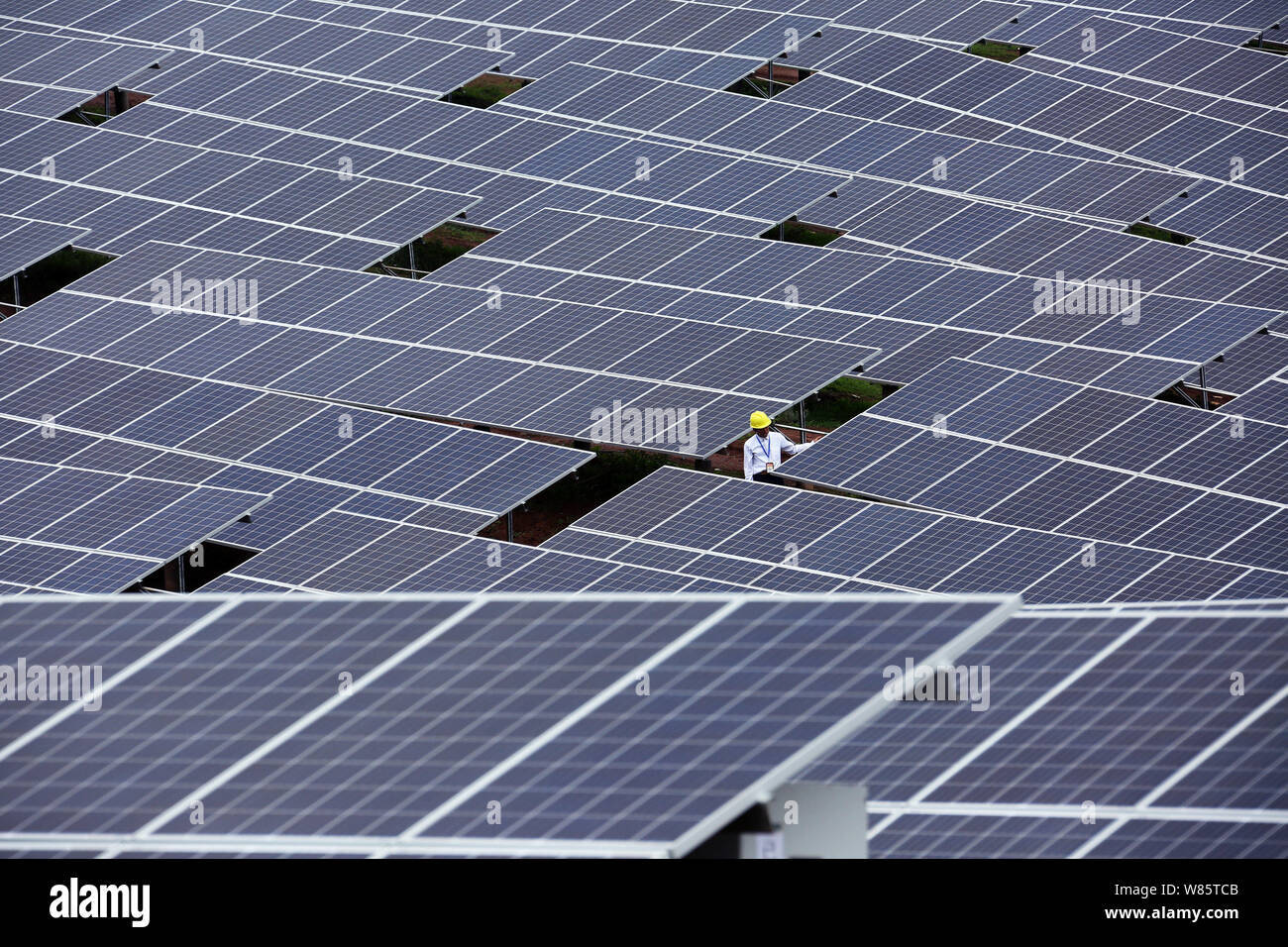 --FILE--A Chinese worker checks solar panels at a photovoltaic power ...