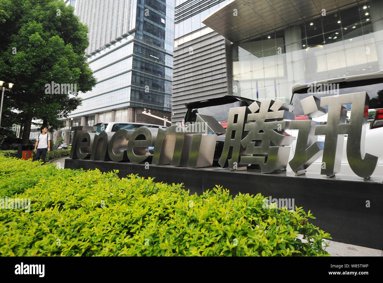 --FILE--A pedestrian walks past the logo of Tencent in front of the ...