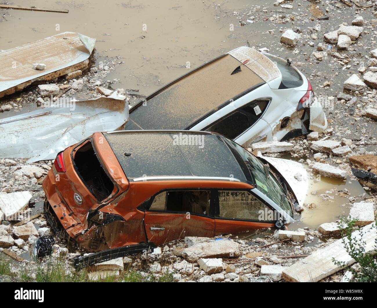 Private cars are submerged in the water after being washed by floods ...