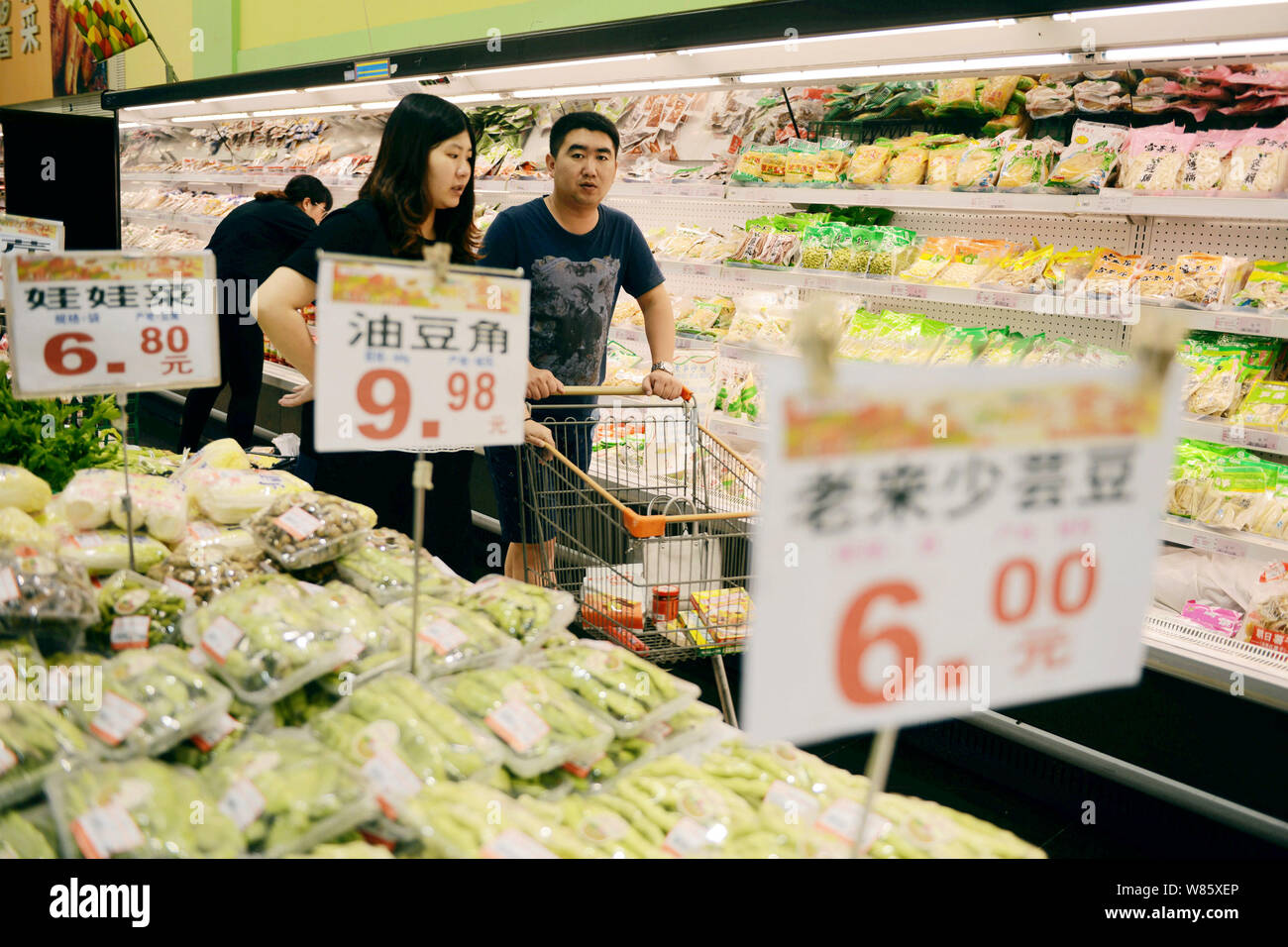 Chinese customers shop for vegetables at a supermarket in Qingdao city ...