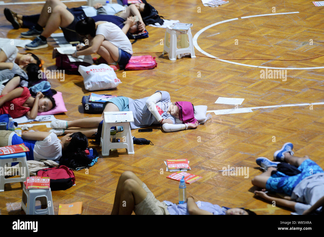 Chinese students rest in a stadium during the break of a tutorial and ...