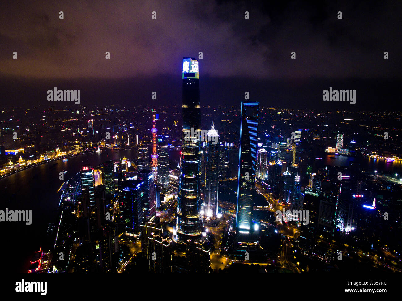 The top of Shanghai Tower, tallest, is illuminated next to other ...