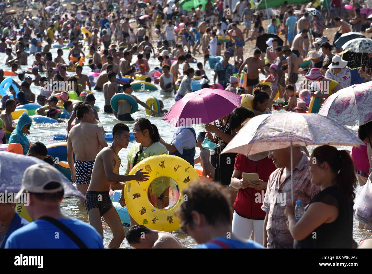 Holidaymakers crowd a beach resort to cool off on a scorching day in ...