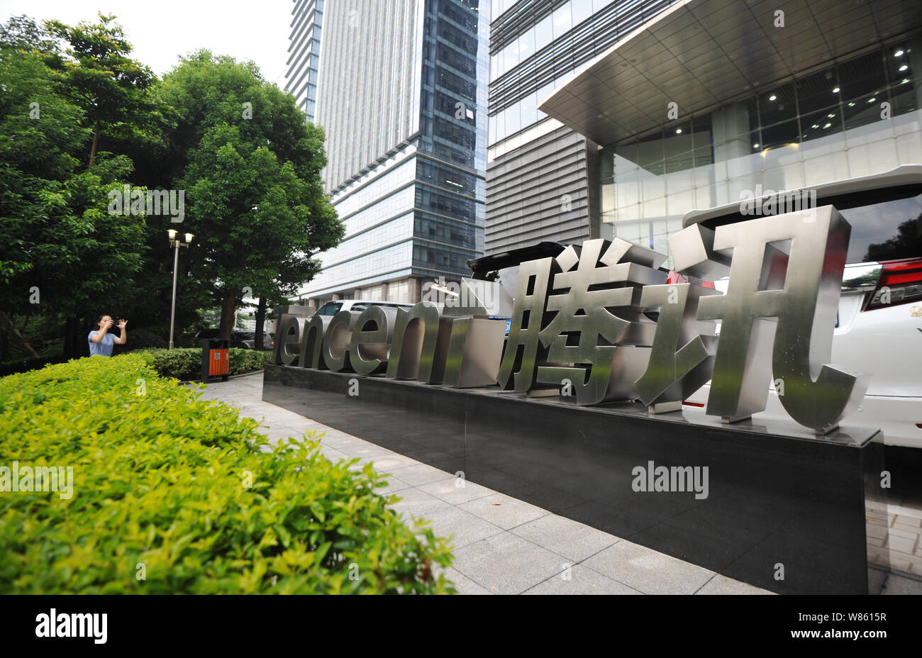 --FILE--A pedestrian walks past the logo of Tencent in front of the ...