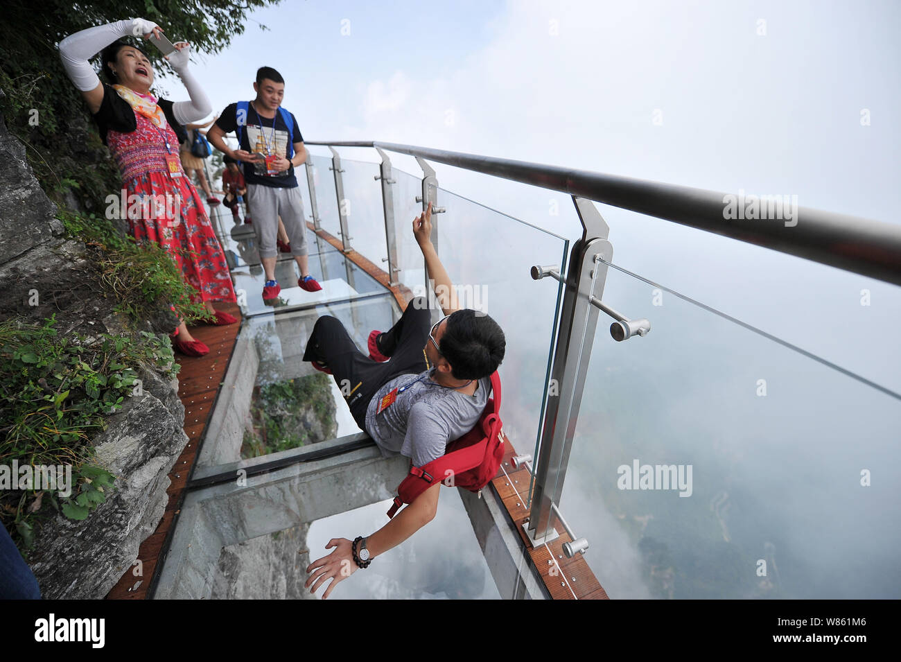 A tourist poses for photos on the 100-meter-long and 1.6-meter-wide ...