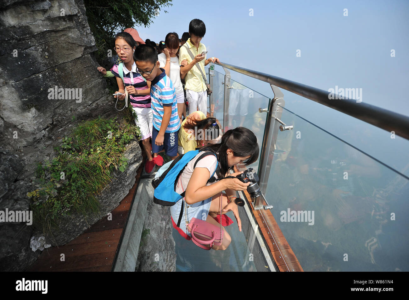 Tourists walk on the 100-meter-long and 1.6-meter-wide glass skywalk on ...