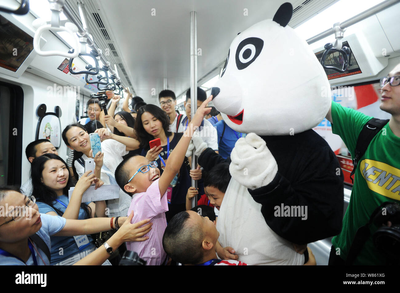 Passengers interact with an employee dressed in a giant panda costume ...