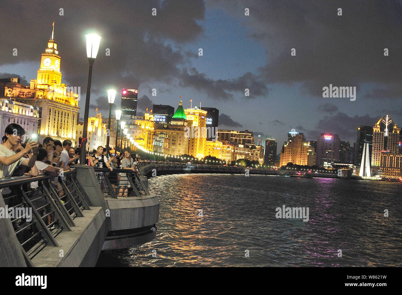 Tourists visit the Bund along illuminated colonial buildings in Puxi ...