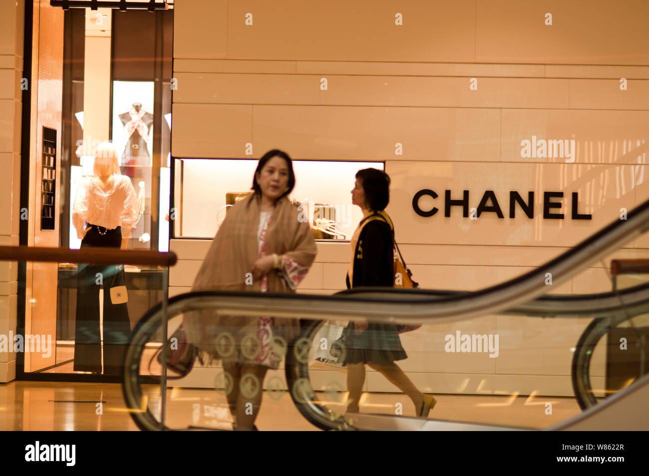 --FILE--Shoppers walk past the fashion boutique of Chanel at the Taikoo ...