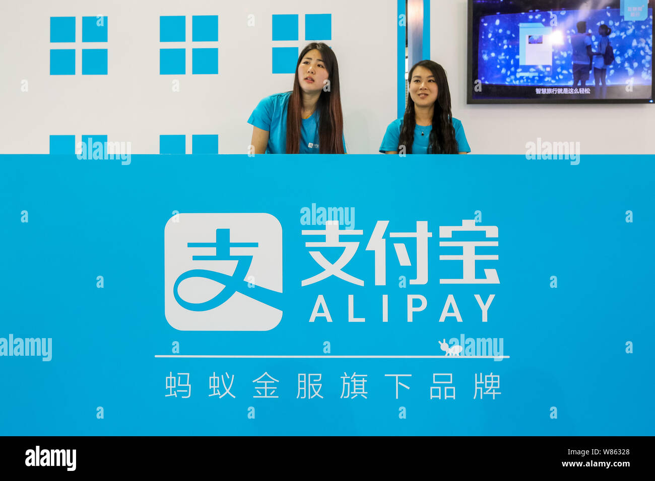--FILE--Chinese employees take a look at the stand of Alibaba's online ...