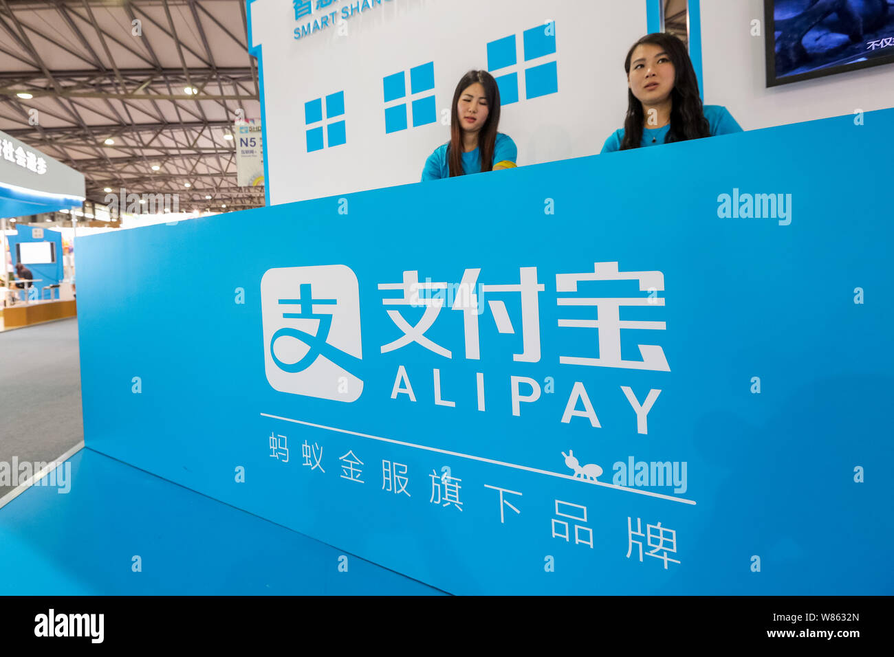 --FILE--Chinese employees are seen at the stand of Alipay of Alibaba ...