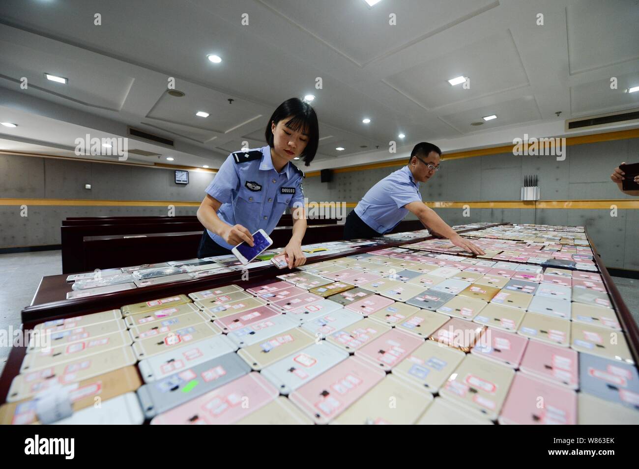 Chinese police officers display smartphones after arresting a ...