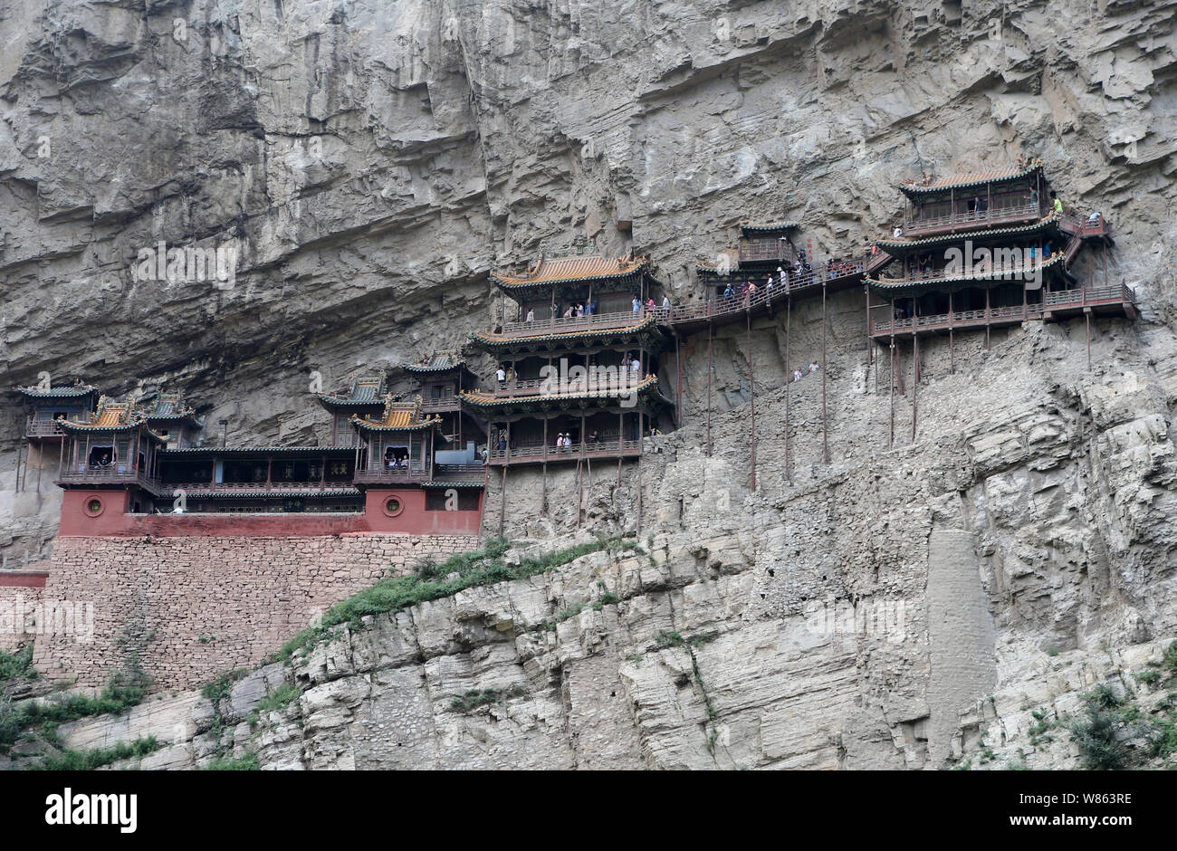 Tourists visit the Hanging Temple, also known as the Hanging Monastery ...