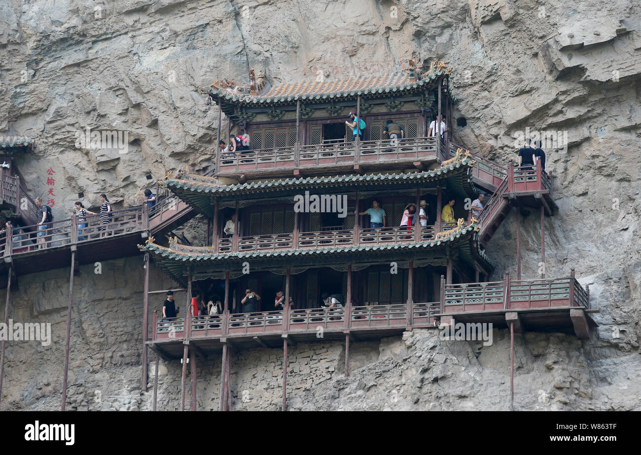 Tourists visit the Hanging Temple, also known as the Hanging Monastery ...