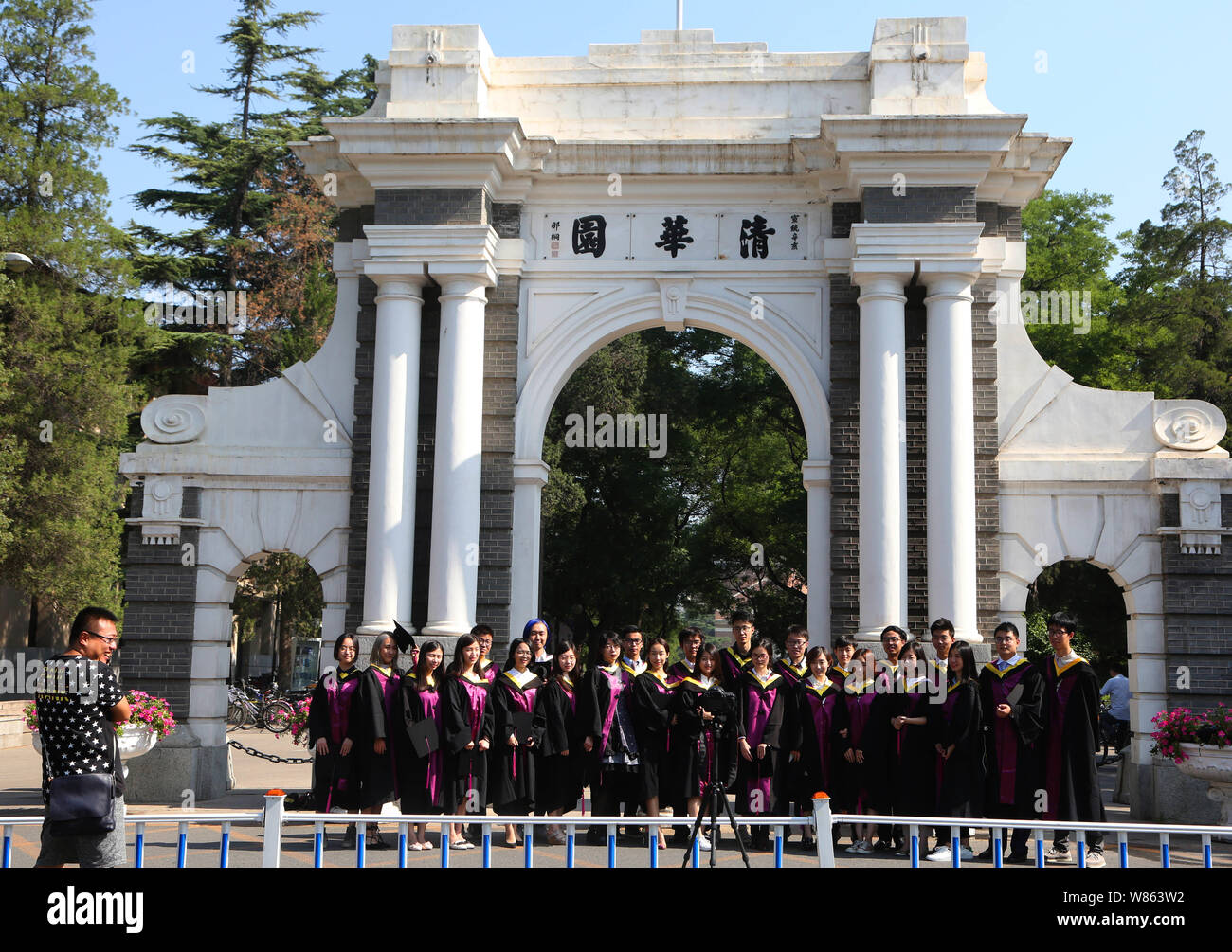 --FILE--Chinese graduates pose for a group shot in front of a gate of ...