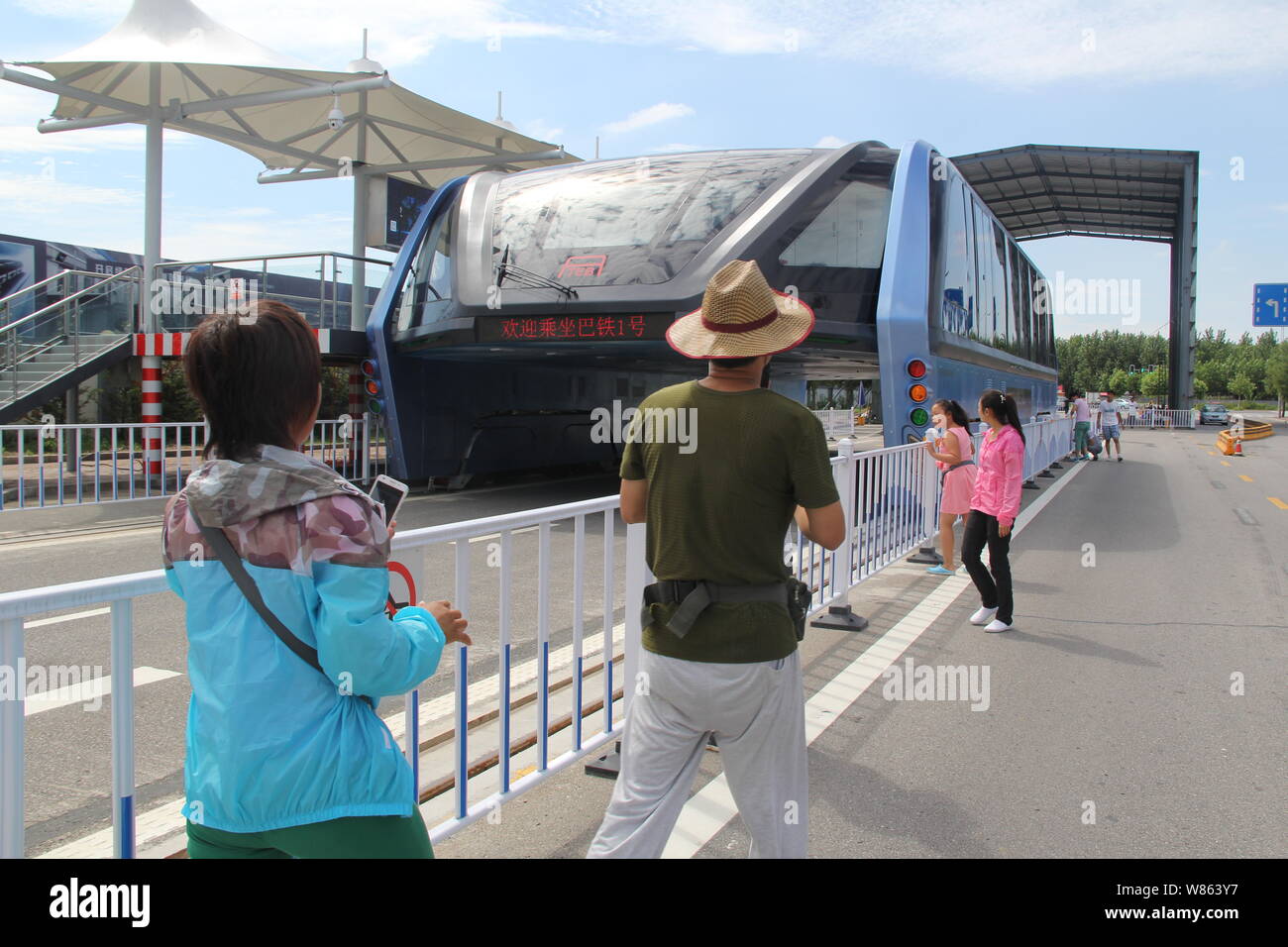 People take photos of the Transit Elevated Bus (TEB) on Fumin road in ...