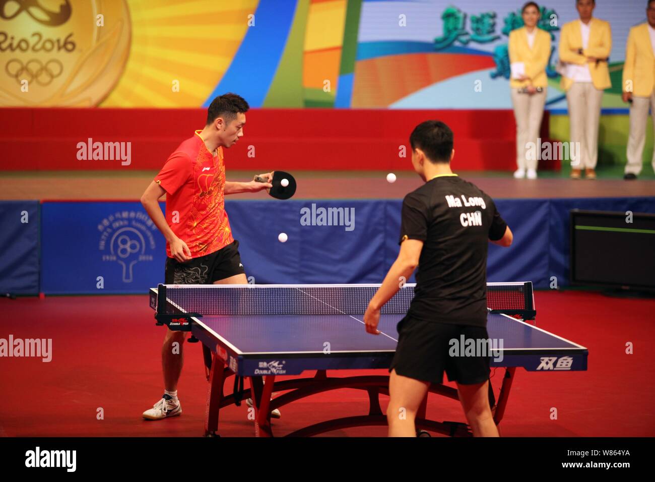 Chinese table tennis players Ma Long, front, and Xu Xin plays with ...