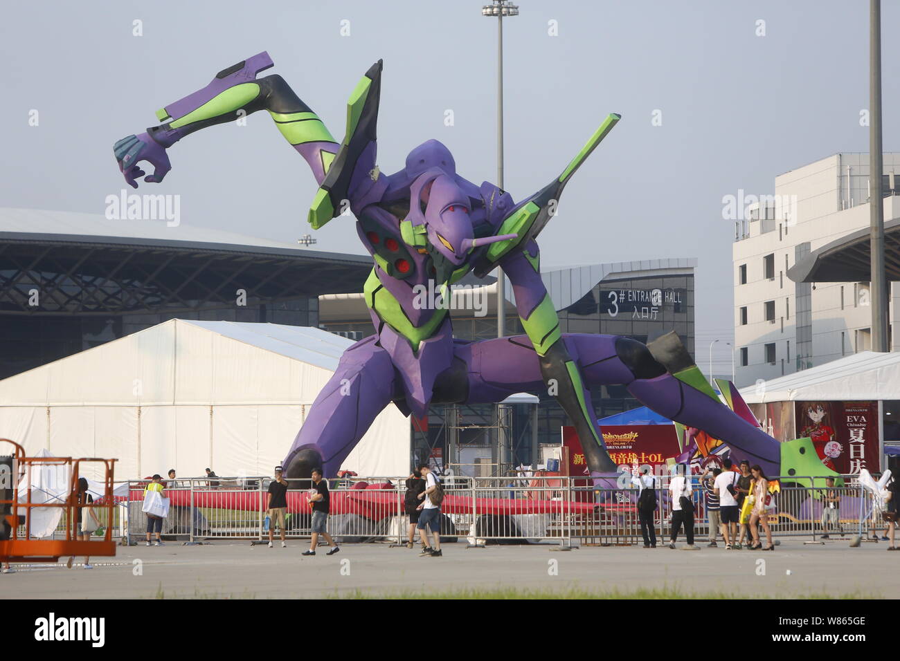 Visitors walk past a giant model of Evangelion from Japanese animated ...