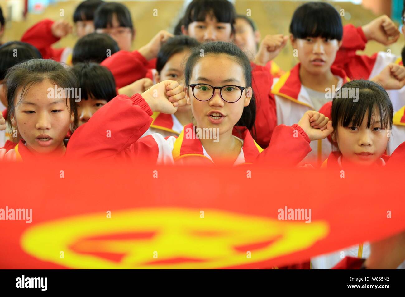 --FILE--Young Chinese students swear in during a ceremony for becoming ...