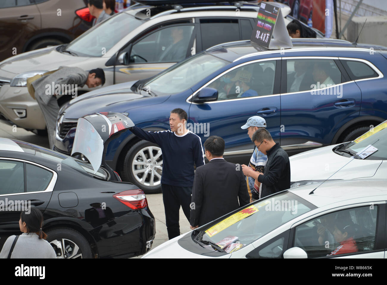--FILE--Visitors look at or try out cars on display during an auto show ...