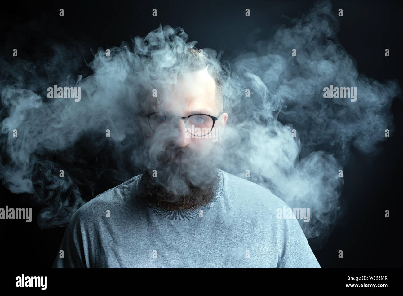 Concept. Smoke enveloped the head man. Portrait of a Bearded, stylish ...