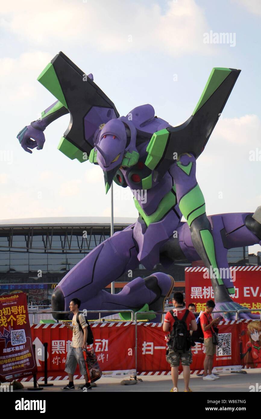 Visitors walk past a giant model of Evangelion from Japanese animated ...