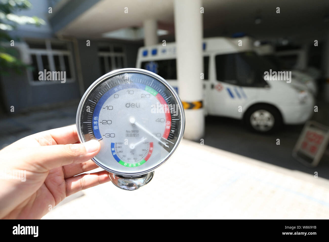 A medical worker displays a thermometer showing the temperature over 50 ...