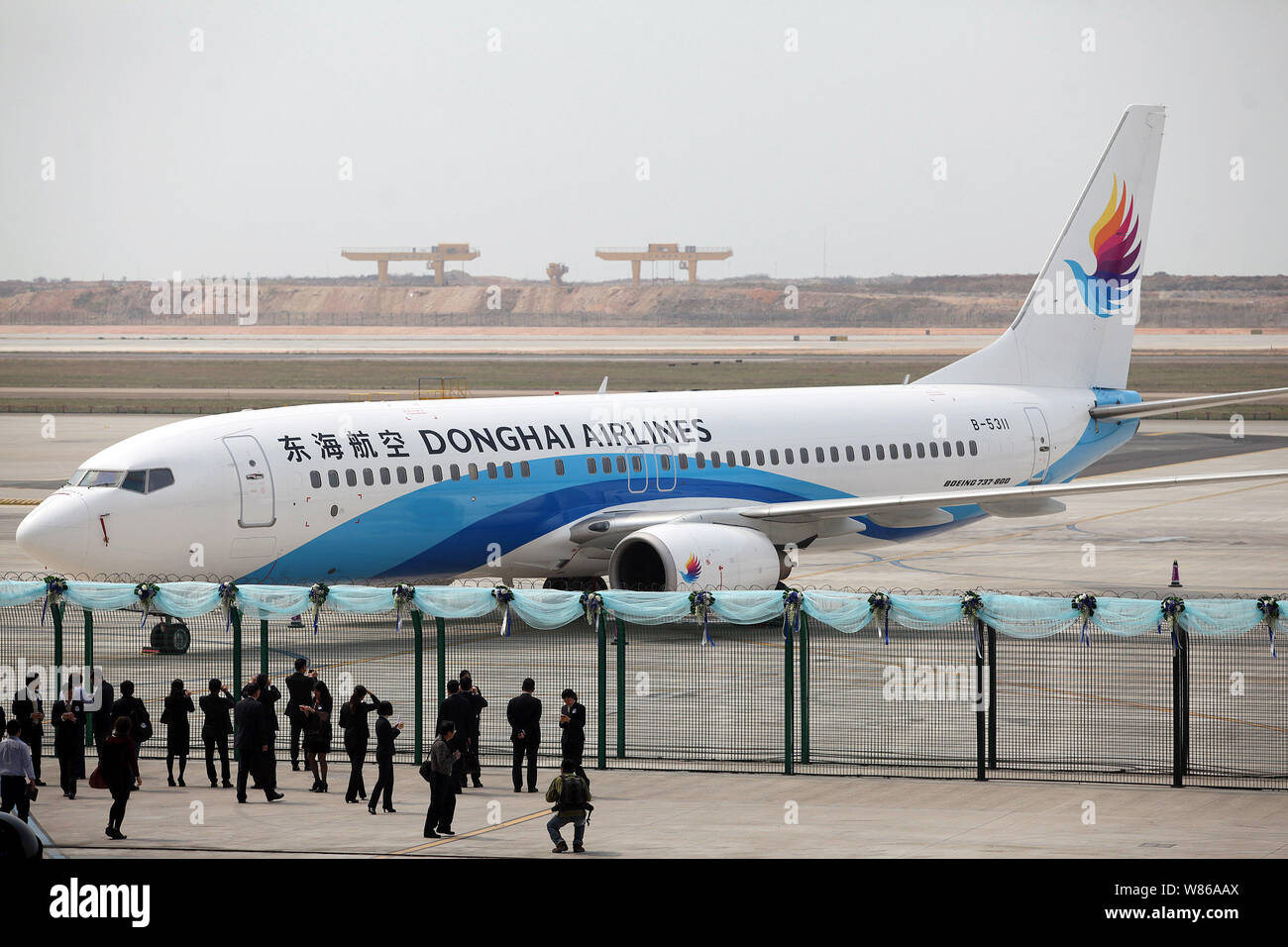 --FILE--People take pictures of or look at a Boeing 737-800 passenger ...