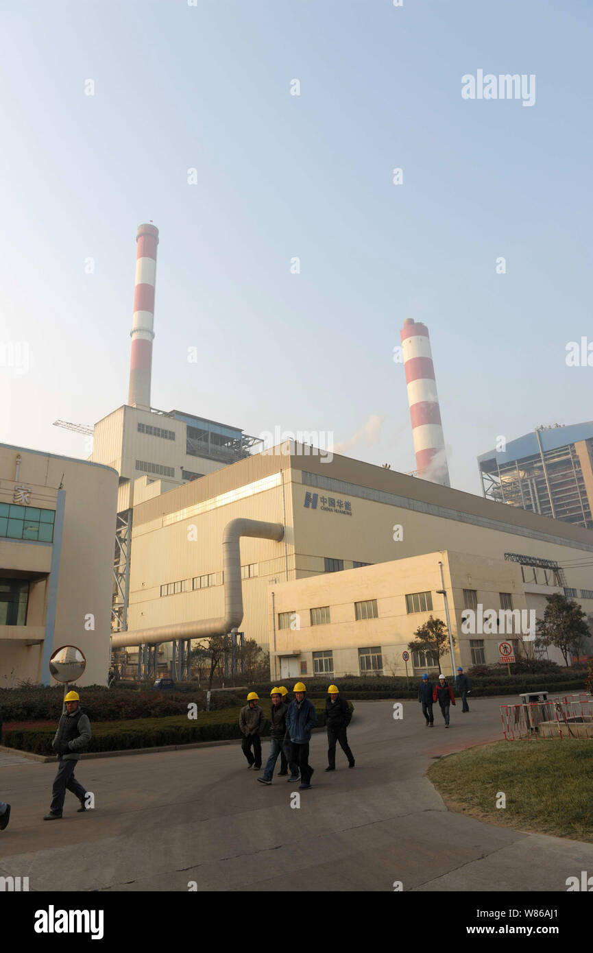 --FILE--Chinese workers walk past buildings at a coal-fired power plant ...