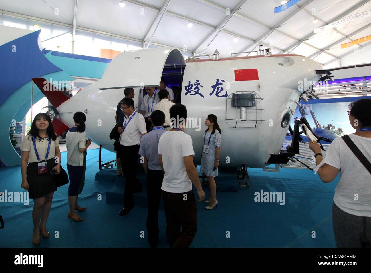Visitors look at a model of Jiaolong (flood dragon), the manned deep ...