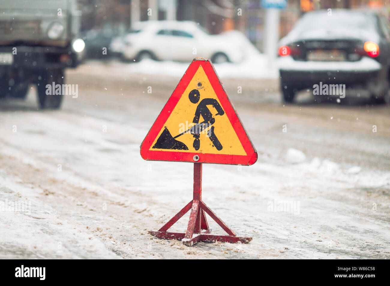 Snow-plow remove snow from the city street.Warning road sign.Winter ...