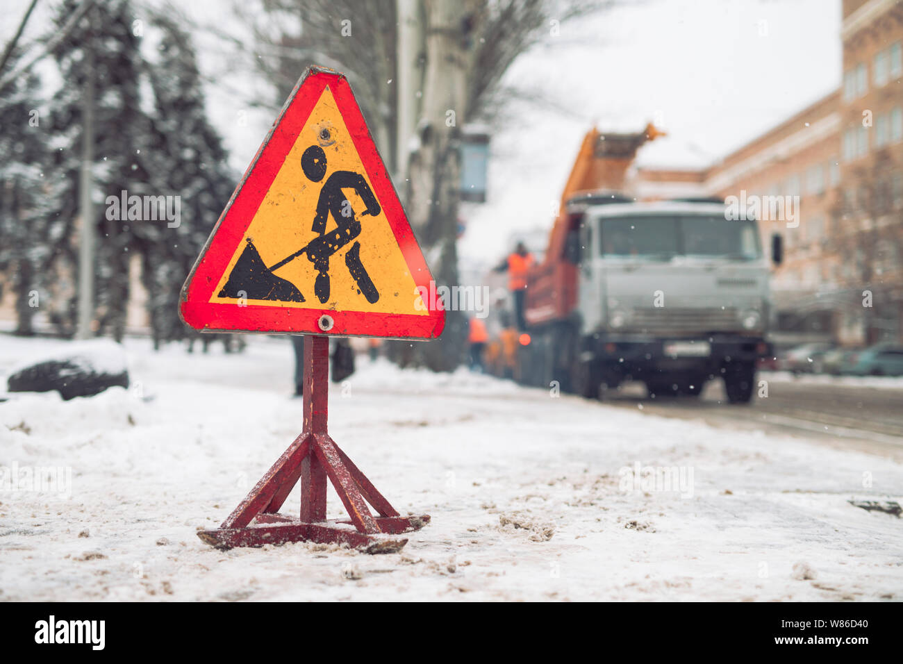 Snow-plow remove snow from the city street.Warning road sign.Winter ...
