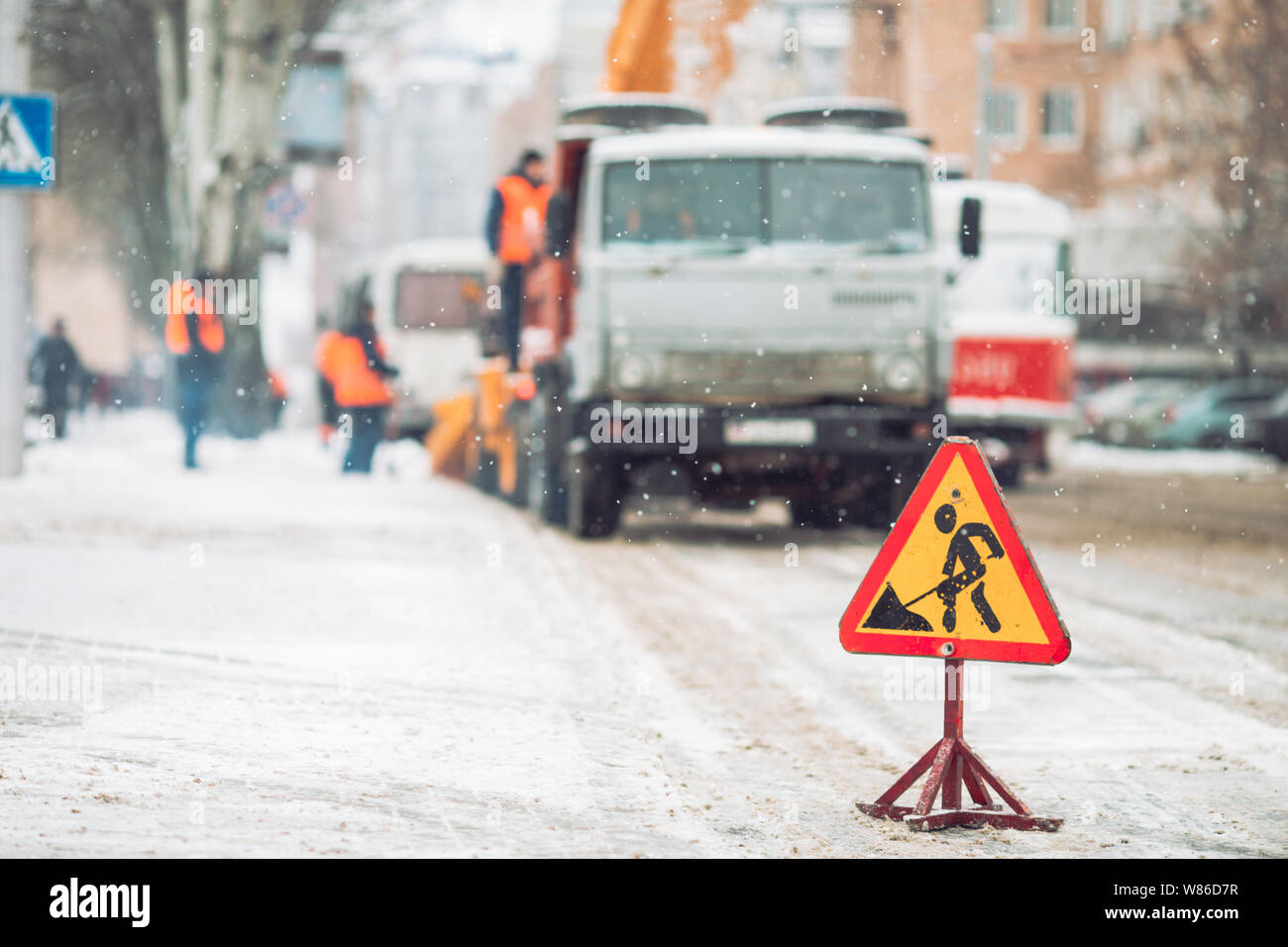 Snow-plow remove snow from the city street.Warning road sign.Winter ...