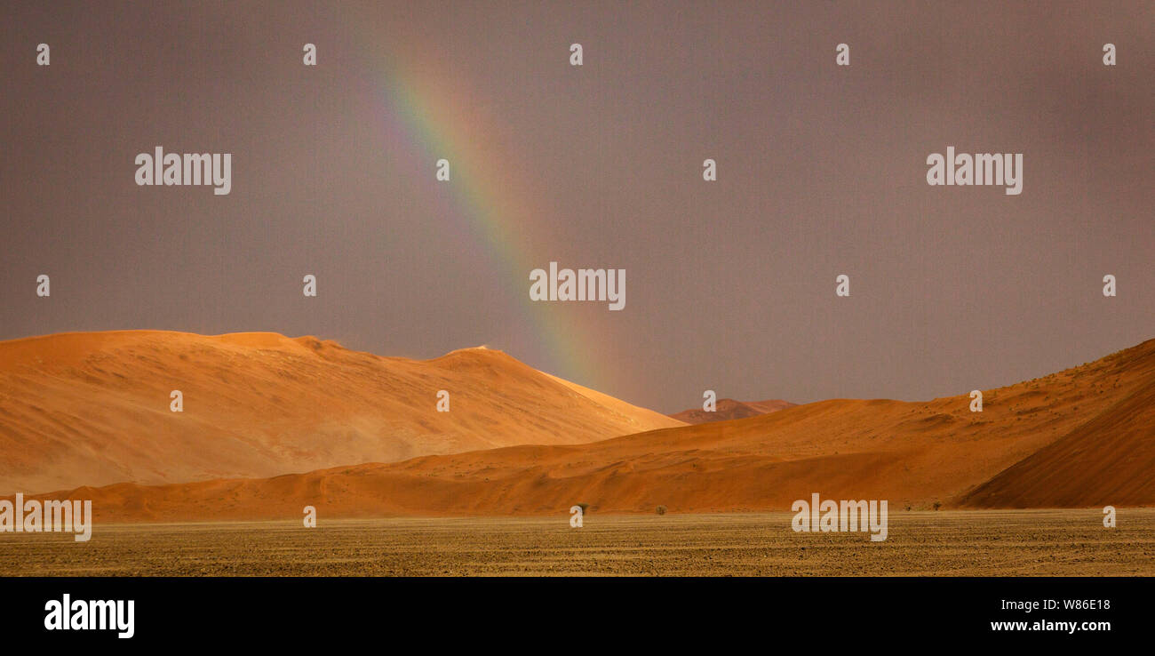 Rainbow shines over a sand dune in the desert in Namibia Stock Photo ...