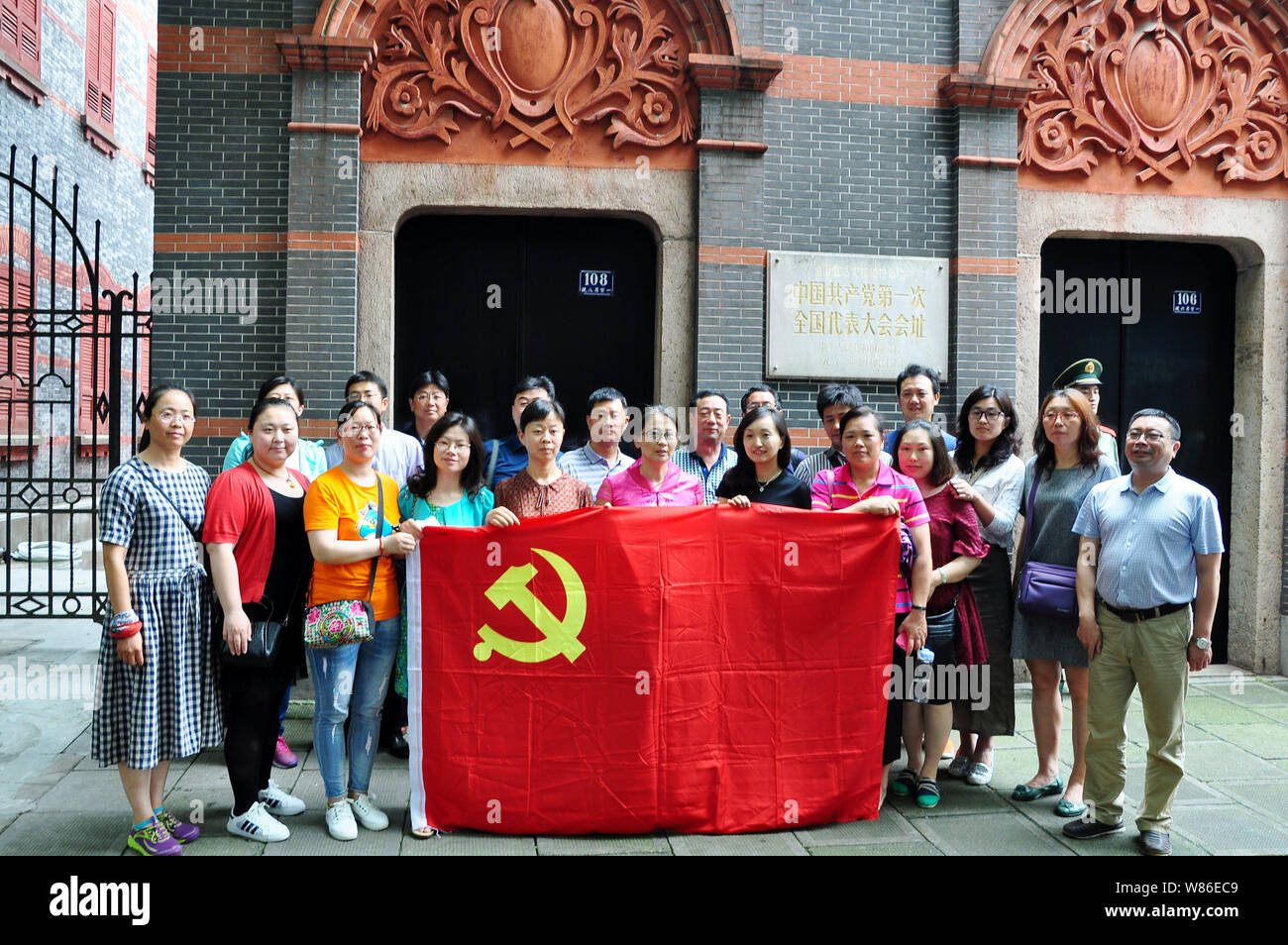 Chinese members of the Communist Party of China pose for photos with a ...