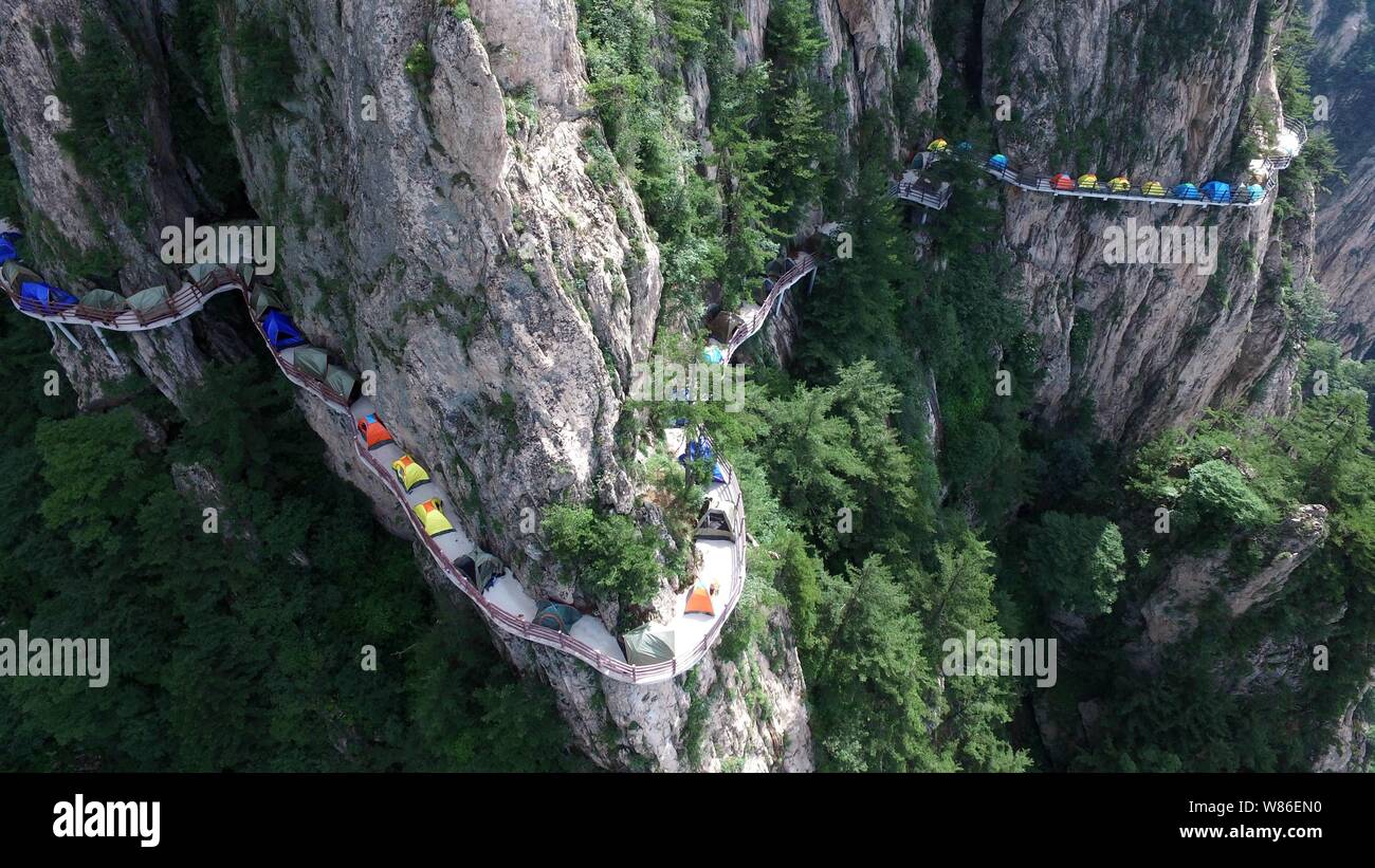 Aerial view of tents set up by backpackers on a walkway along the edge ...