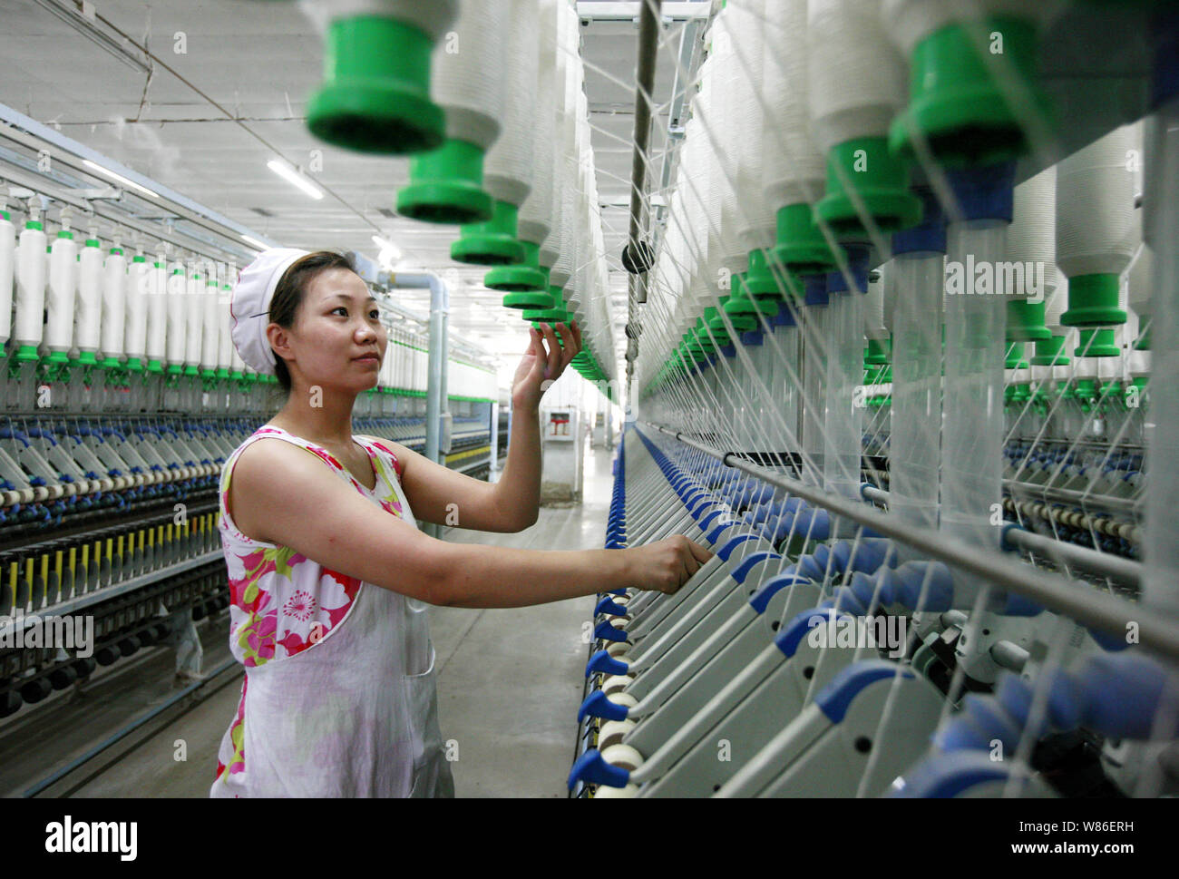 --FILE--A female Chinese worker handles production of yarn at a textile factory in Huaibei city ...
