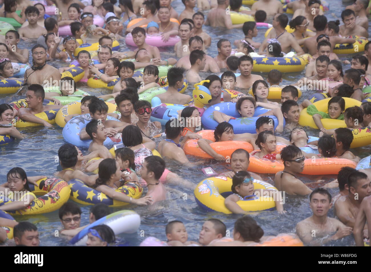 Chinese holidaymakers crowd a swiming pool at a water park on a ...