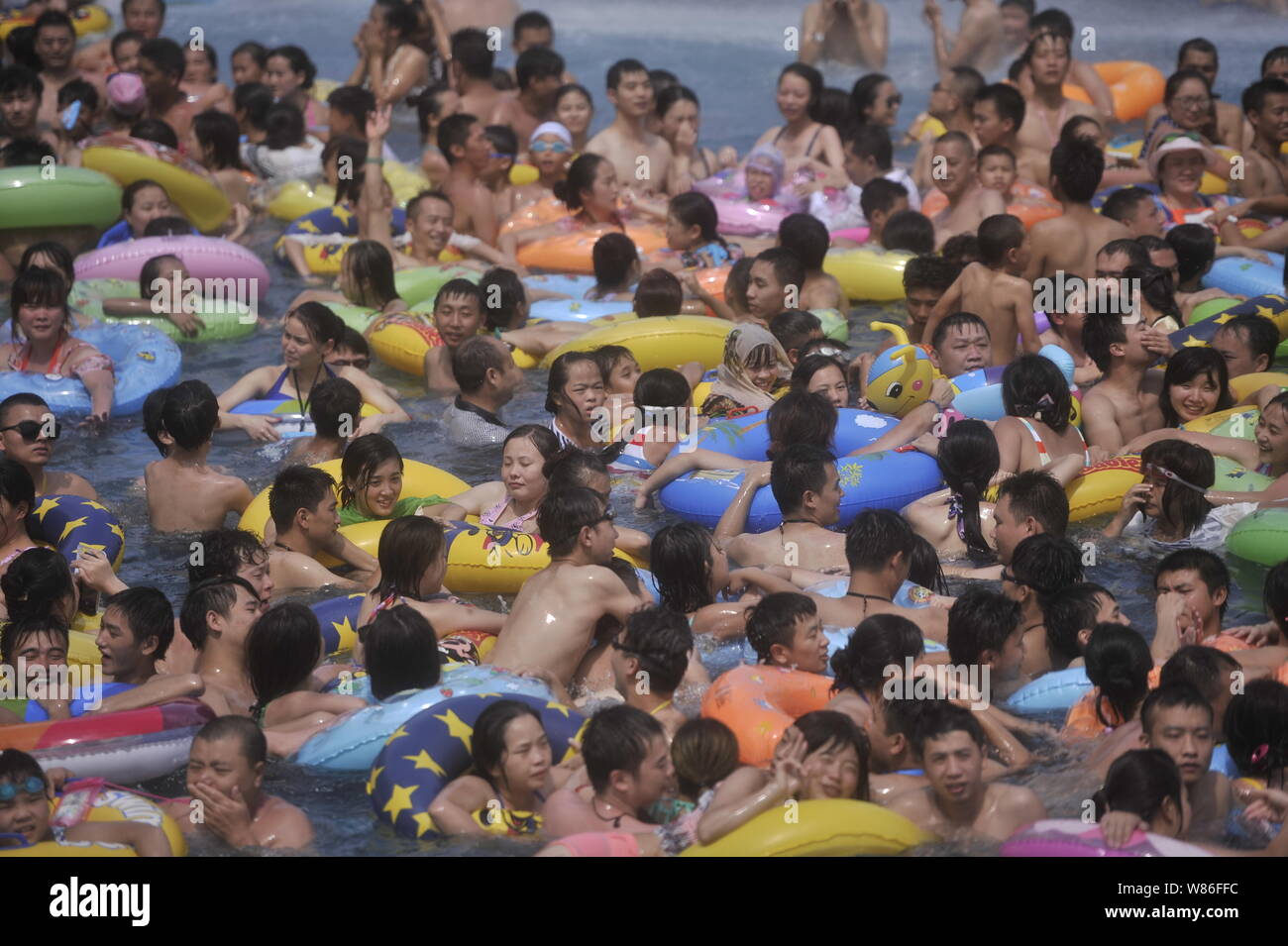 Chinese holidaymakers crowd a swiming pool at a water park on a ...
