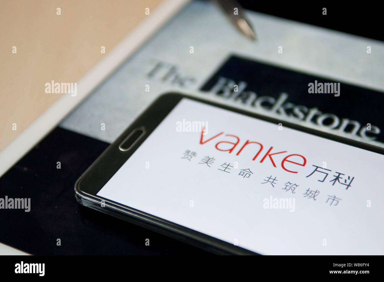 --FILE--An image of the logo of Vanke is displayed on a smartphone over ...