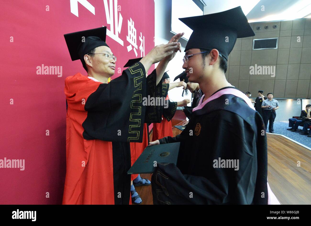 A school official puts an academic hat on An Yongrui, right, the only ...