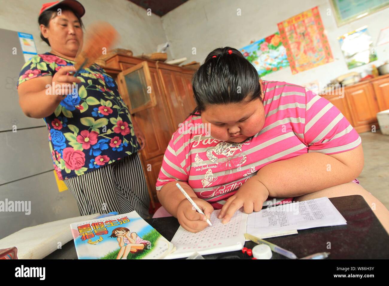 --FILE--An obese Chinese girl does homework at home in Rongcheng ...