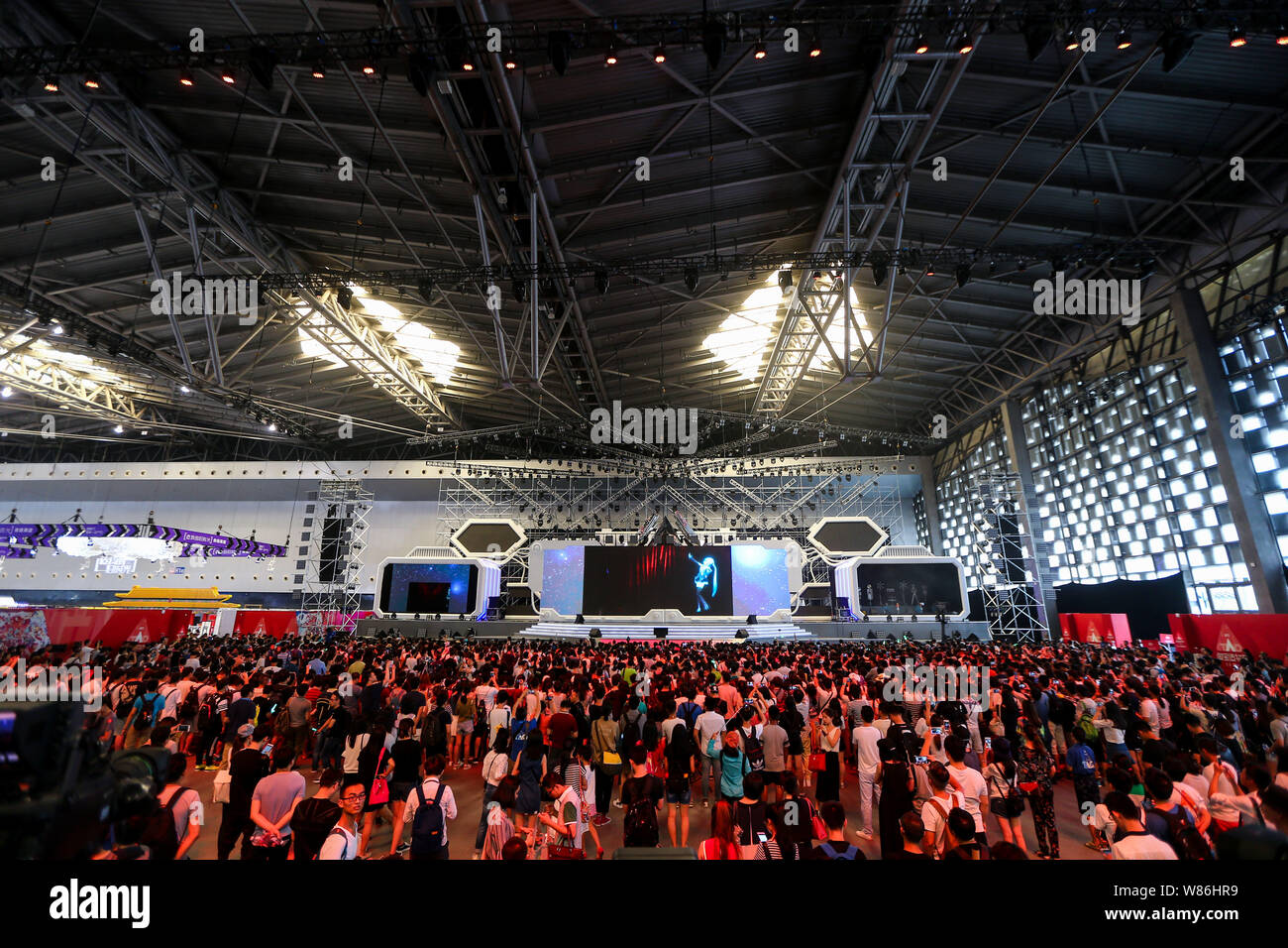 A crowd of visitors watch a performance of Hatsune Miku, a humanoid ...