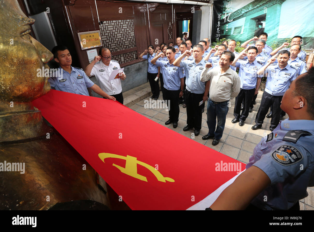 Chinese police officers swear in before a flag of the Communist Party ...