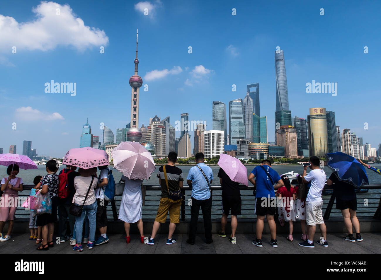 Tourists on the Bund look at the skyline of the Lujiazui Financial ...