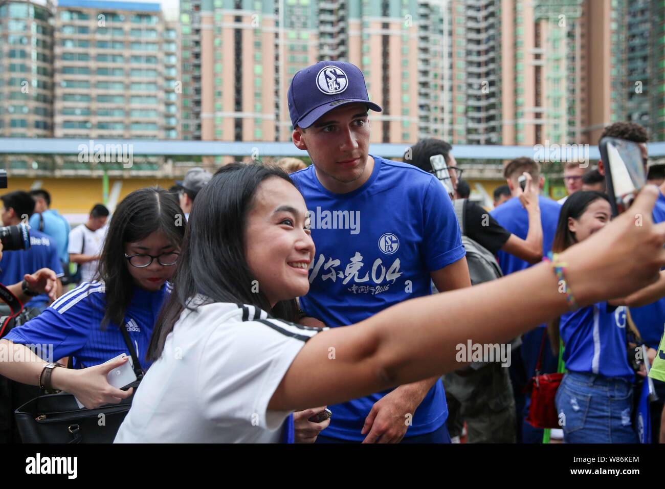 A member, center, of Germany's FC Schalke 04 poses with Chinese fans ...