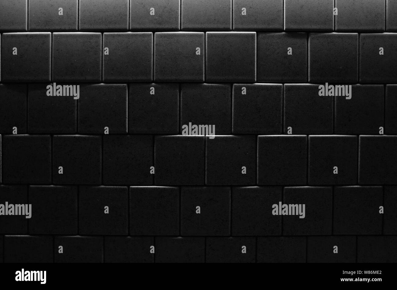 Tiled wall in dark room with poor illumination, background photo ...
