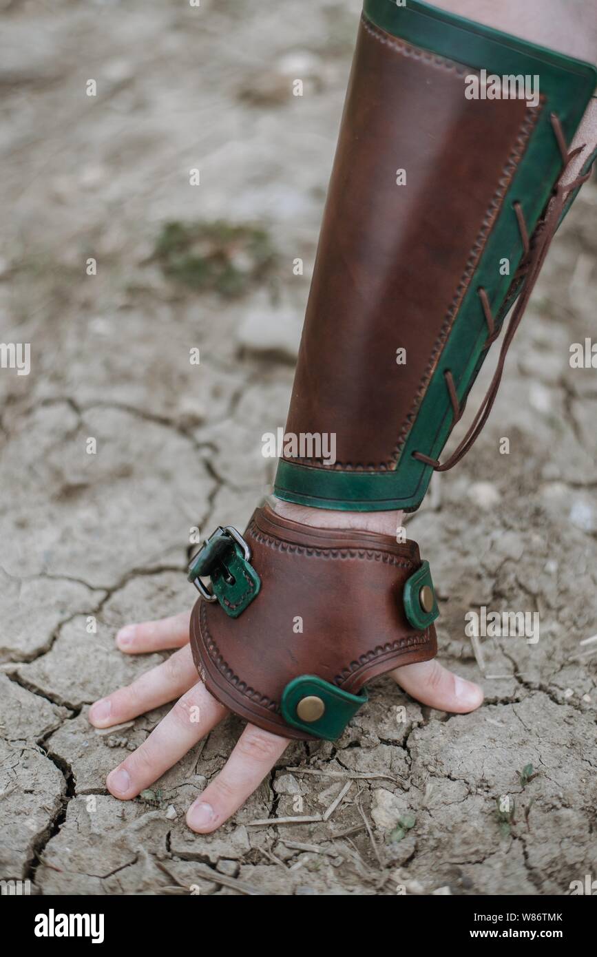 Closeup shot of a person wearing hand armor with the palm put on ground ...